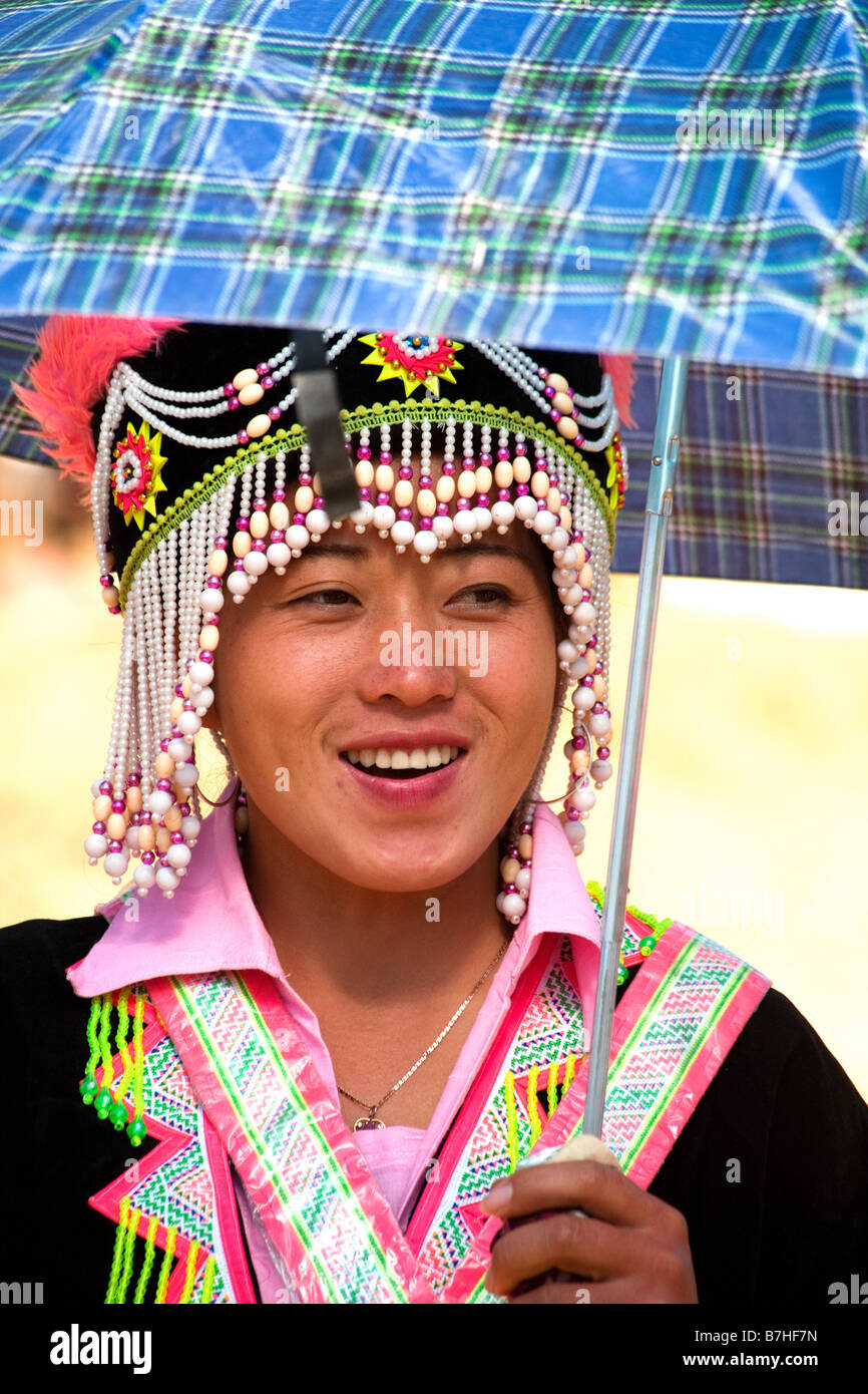A Hmong women, in traditional costume, under an umbrella at a Hmong New ...