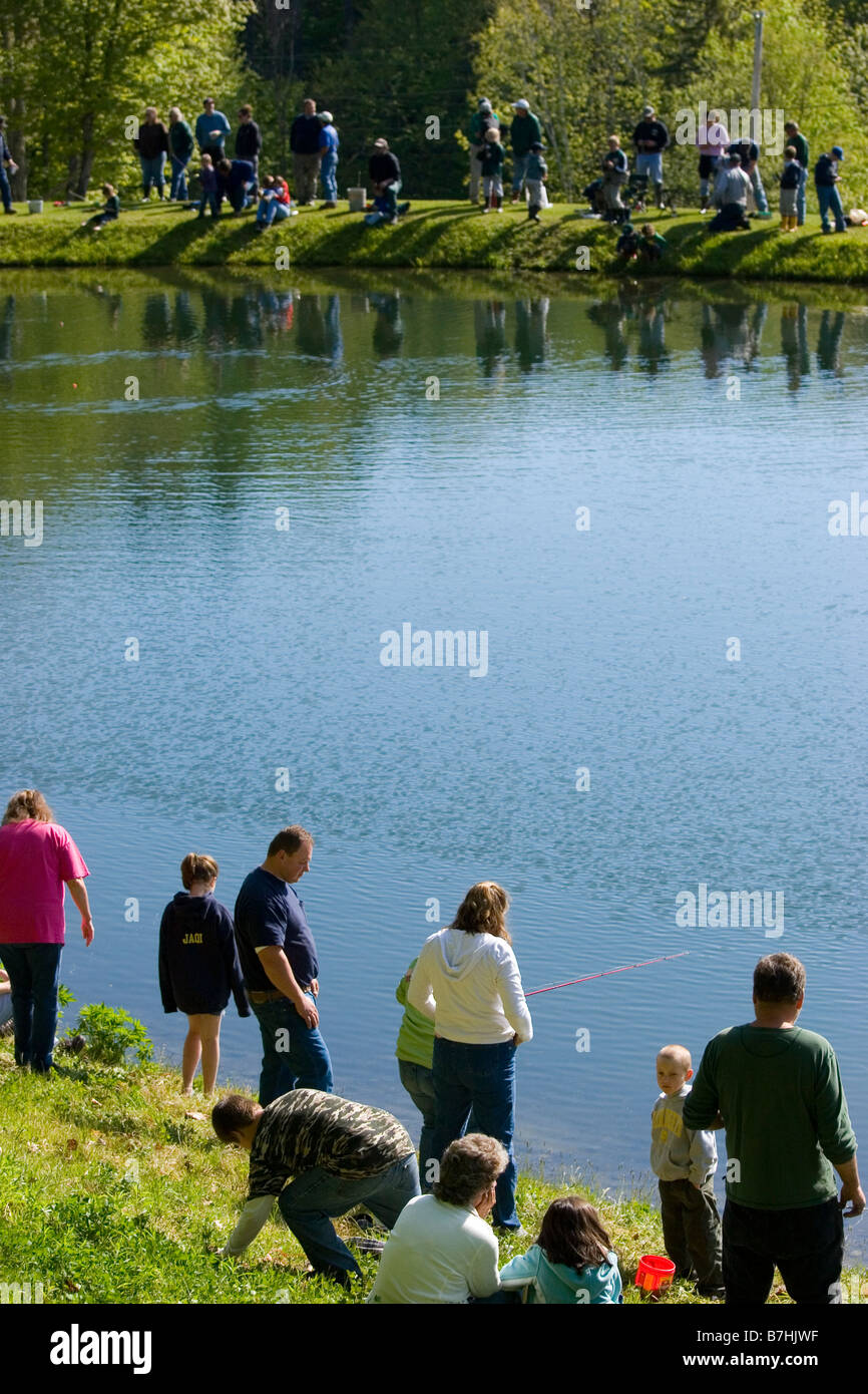Families gathered around pond for summer morning fishing derby ...