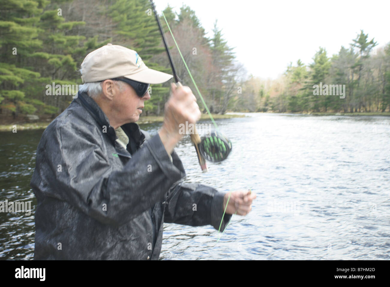 an elderly man fly fishing Stock Photo - Alamy
