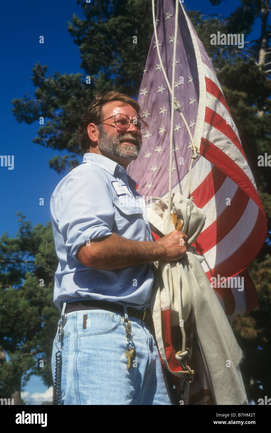 Male custodian prepares to raise American flag over his school Stock ...