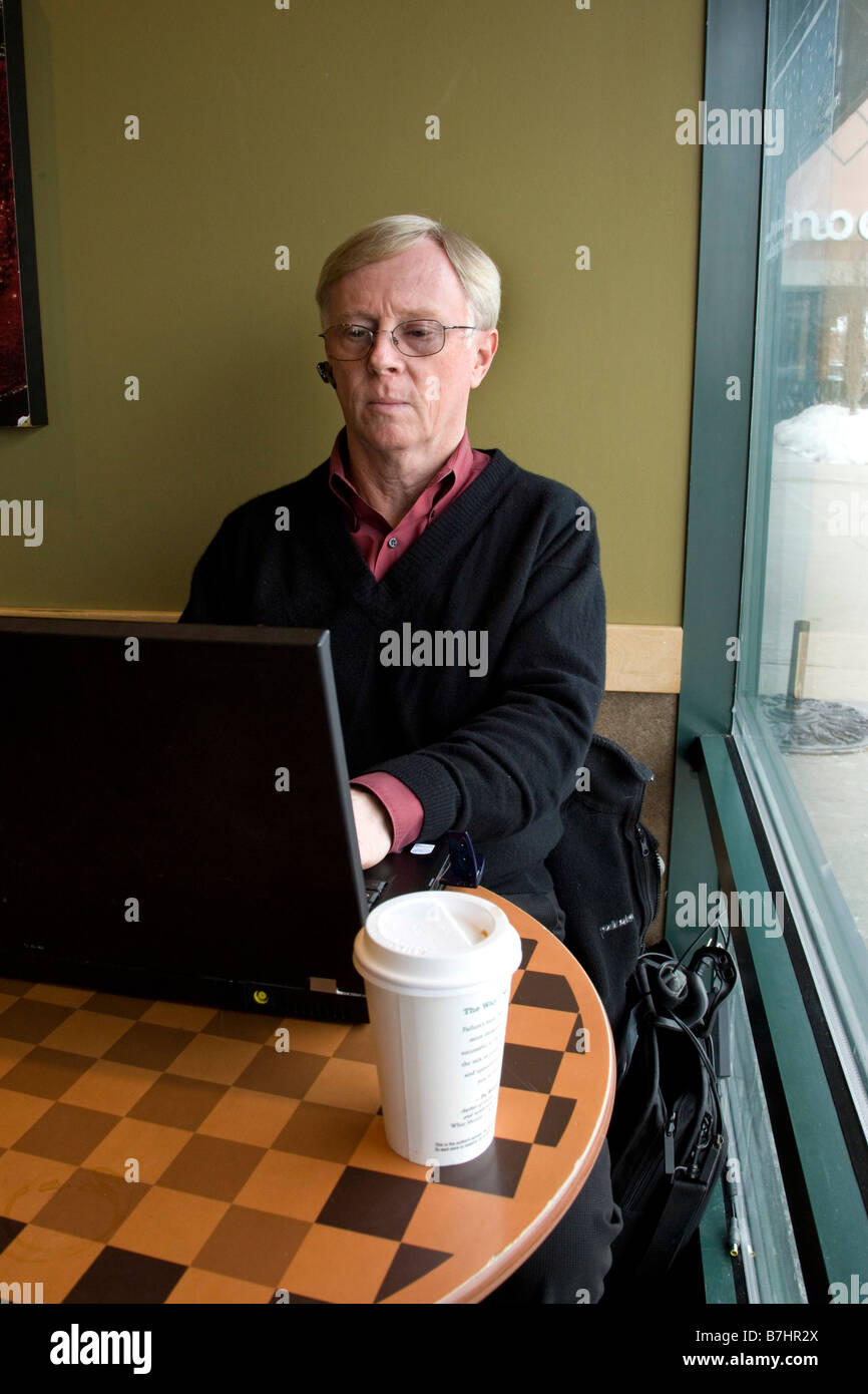 Man working on laptop computer in coffee shop Stock Photo - Alamy