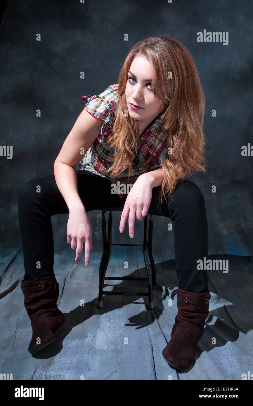 Beautiful dirty blond girl sitting on stool with attitude Stock Photo ...