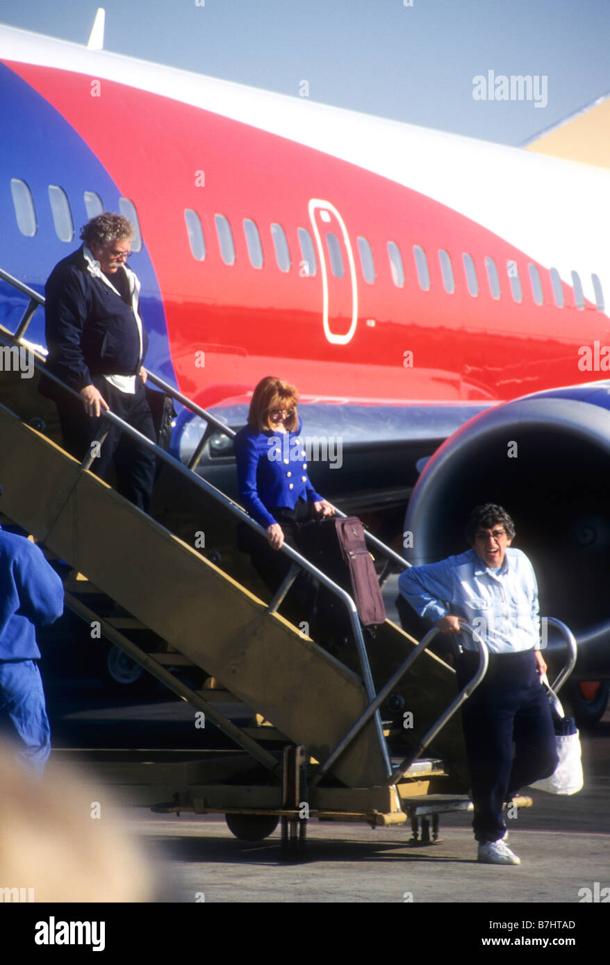 Passengers walk down ramp as they leave passenger jet Stock Photo - Alamy