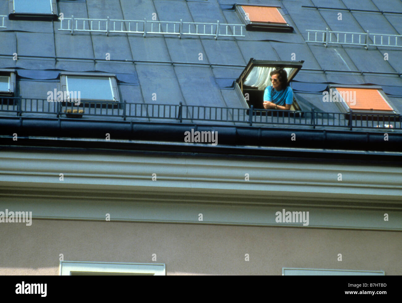 Person reads in open dormer window in Swiss building Stock Photo - Alamy