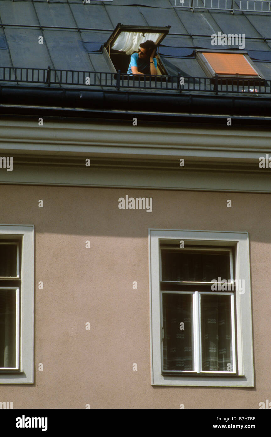 Person reads in open dormer window in Swiss building Stock Photo - Alamy