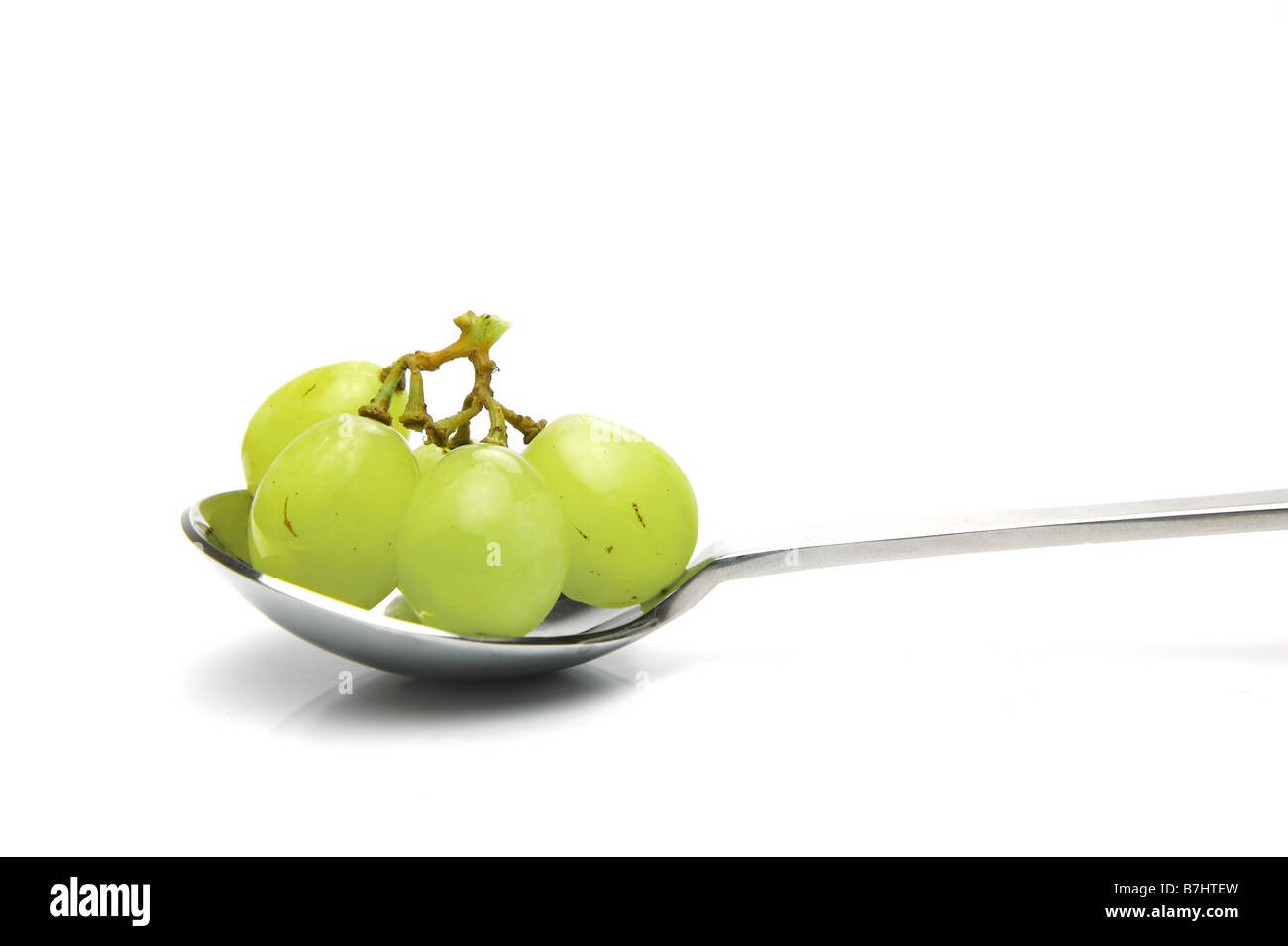 Grapes on a spoon isolated against a white background Stock Photo - Alamy