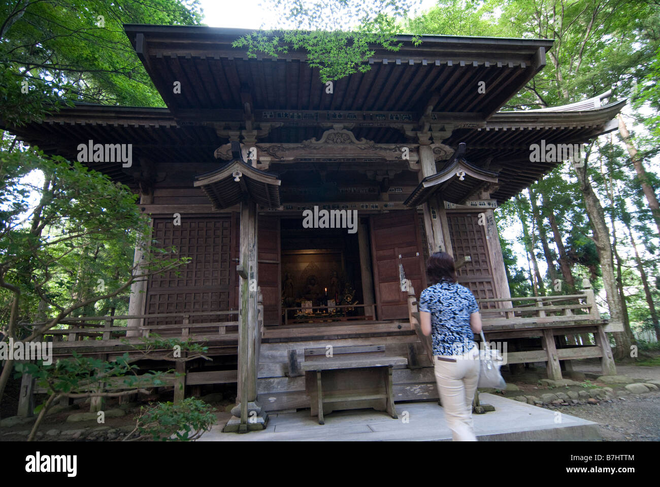 A worshipper approaches a temple building at Chusonji temple, Hiraizumi ...