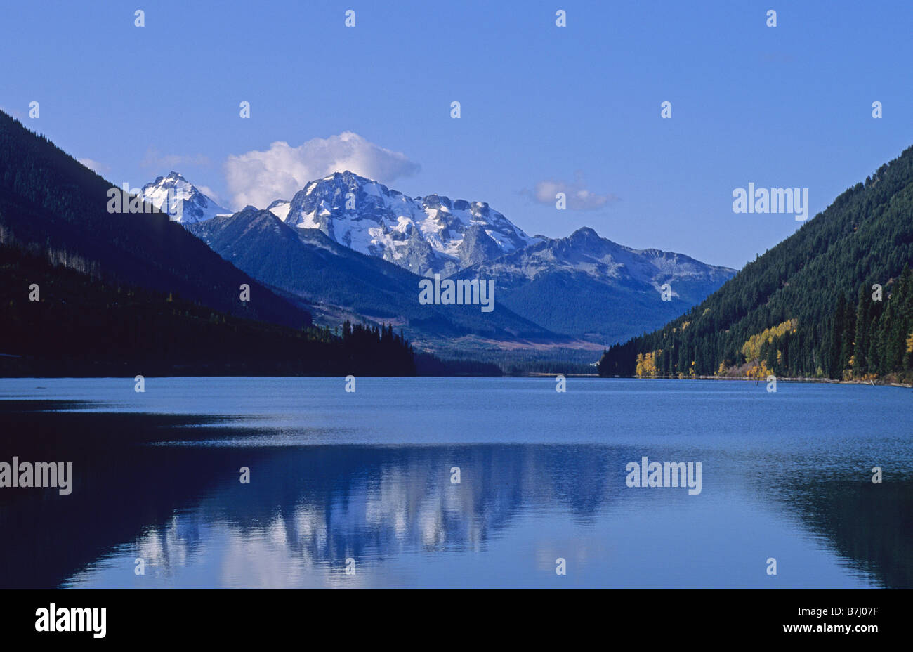 The mountains above Carpenter Lake are reflected in early winter, B.C ...