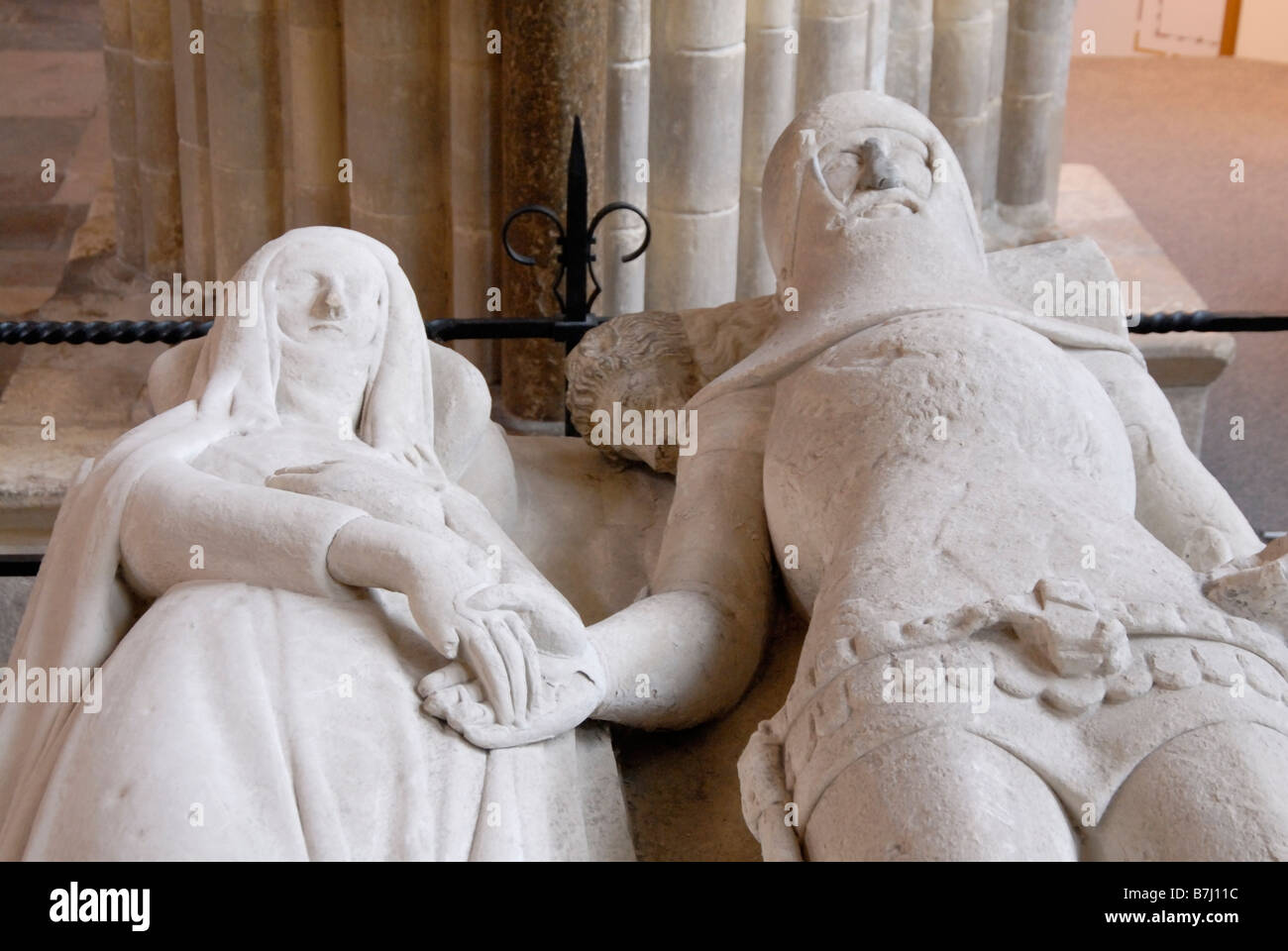 14th century stone effigies of a knight in armor holding hands with his ...