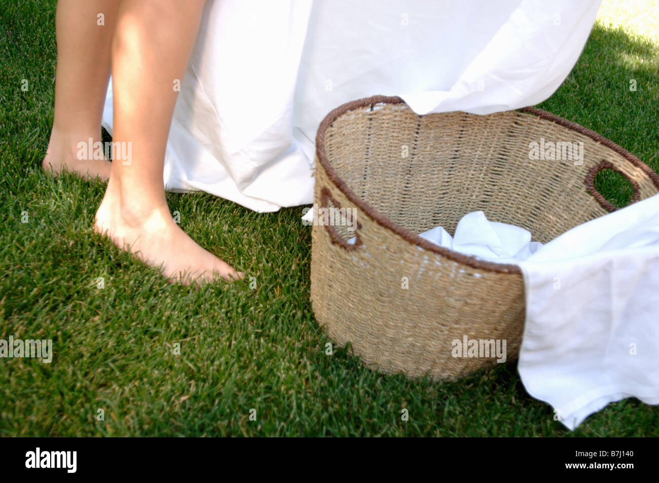 Woman's feet in grass with laundry basket, Regina, Saskatchewan Stock ...