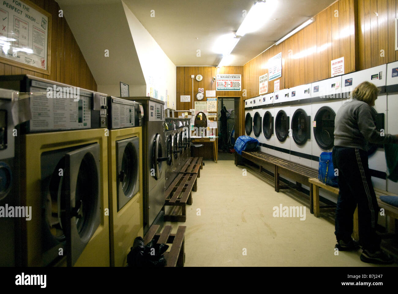 Woman in launderette at night doing washing Stock Photo - Alamy