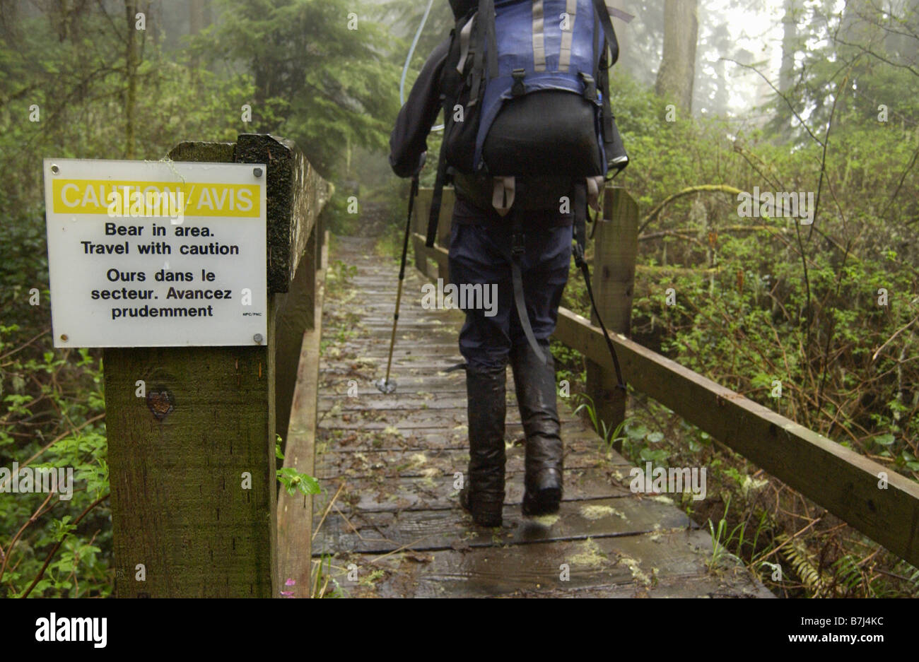 Backpacker walking past a sign saying Bear in area, West Coast Trail ...