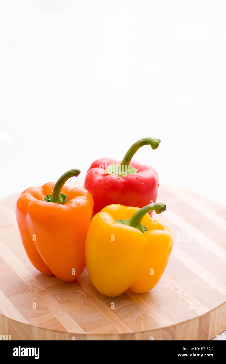 Yellow, orange and red peppers on butcher block cutting board Stock ...