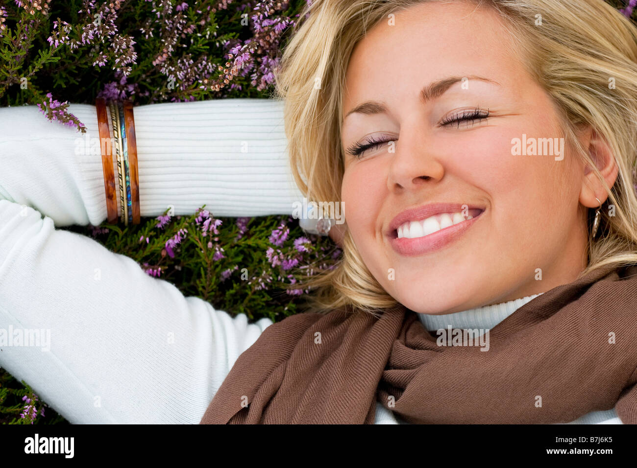 A beautiful blond haired blue eyed laying down and thinking happy ...