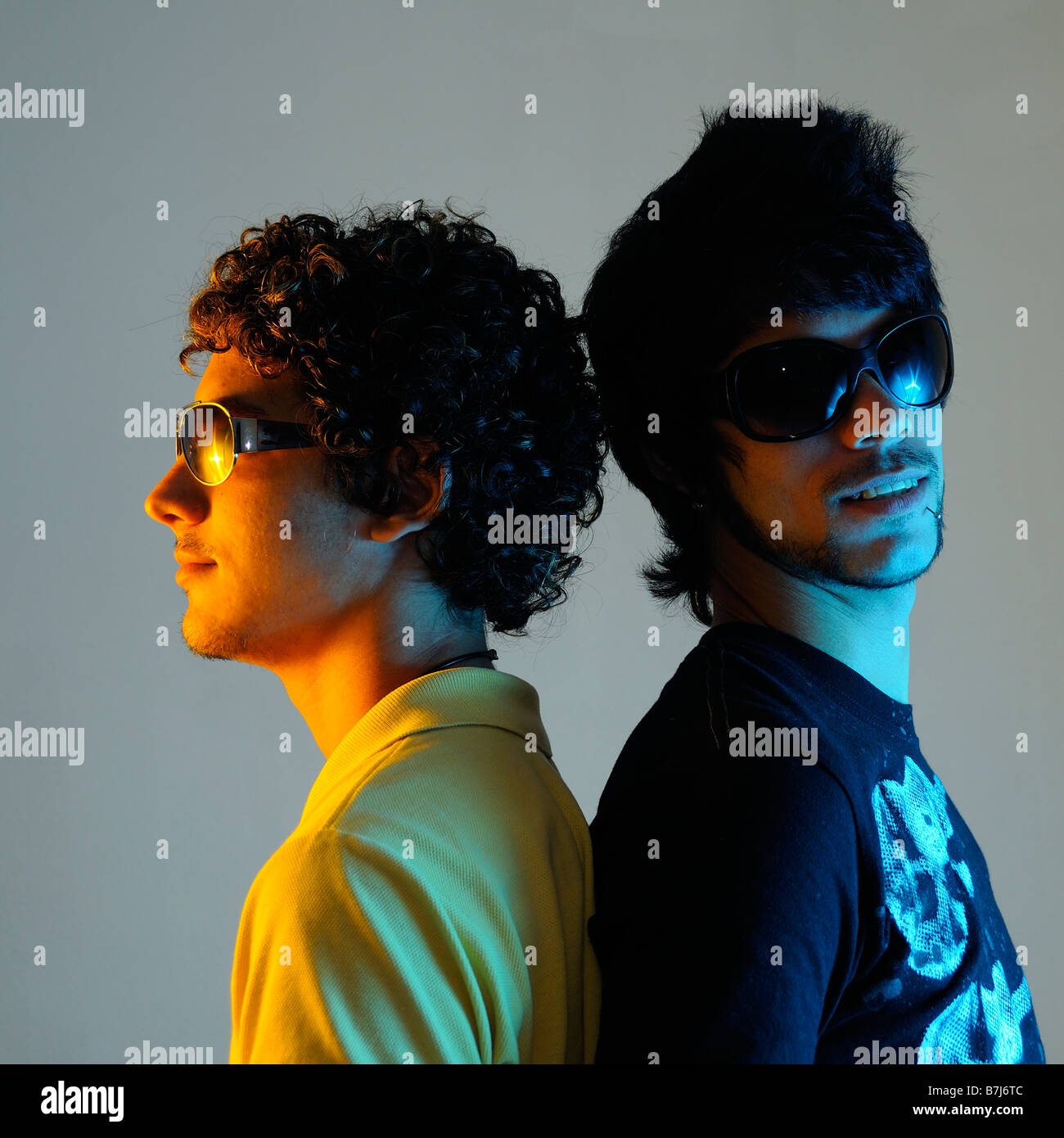 Portrait of two casual young friends standing back to back Stock Photo ...