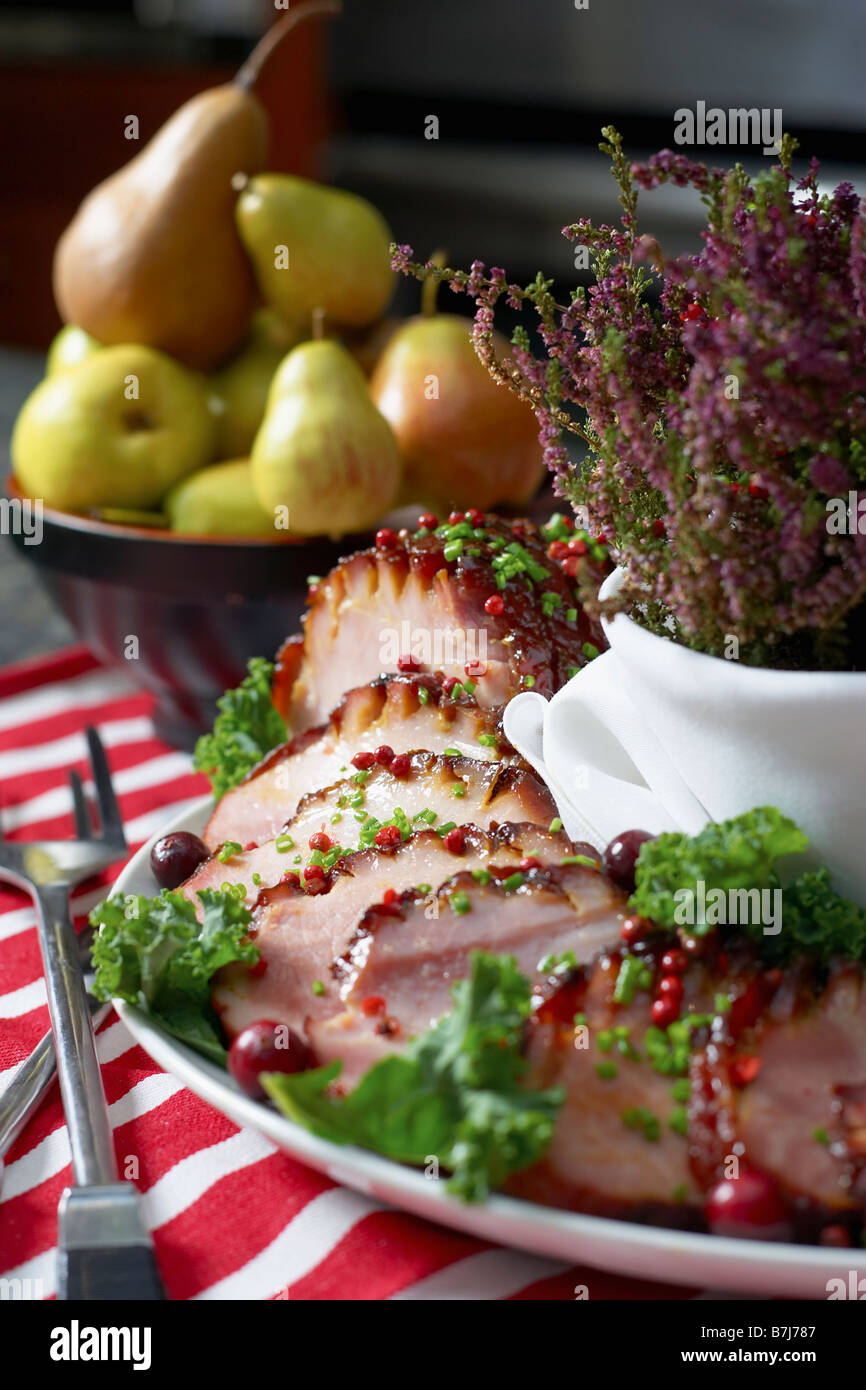 Festive oven roasted ham sliced and garnished with chives and ...