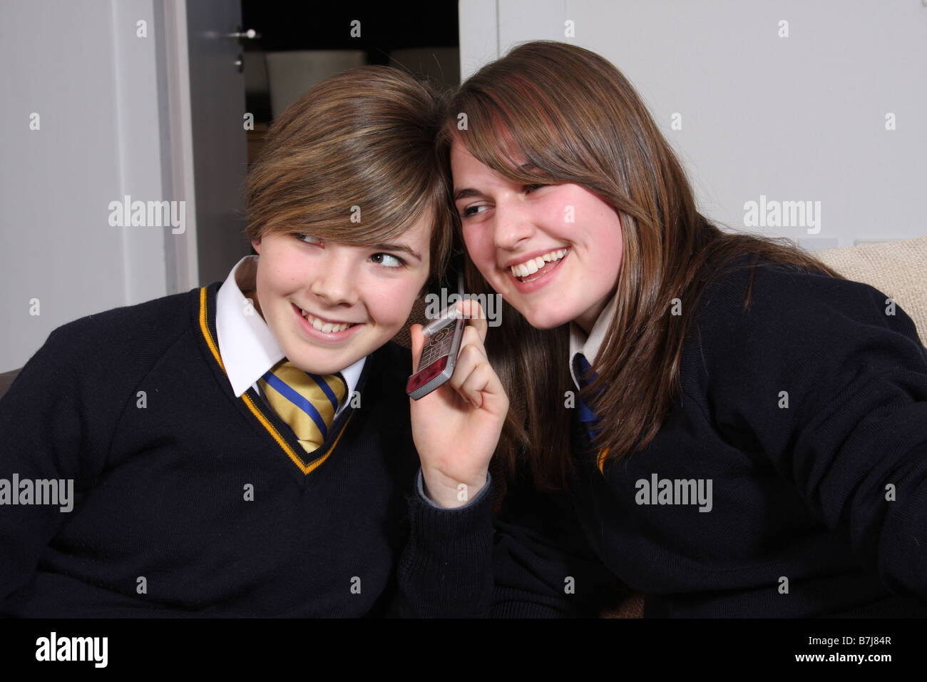 Two teenage girls listening together on a phone Stock Photo - Alamy