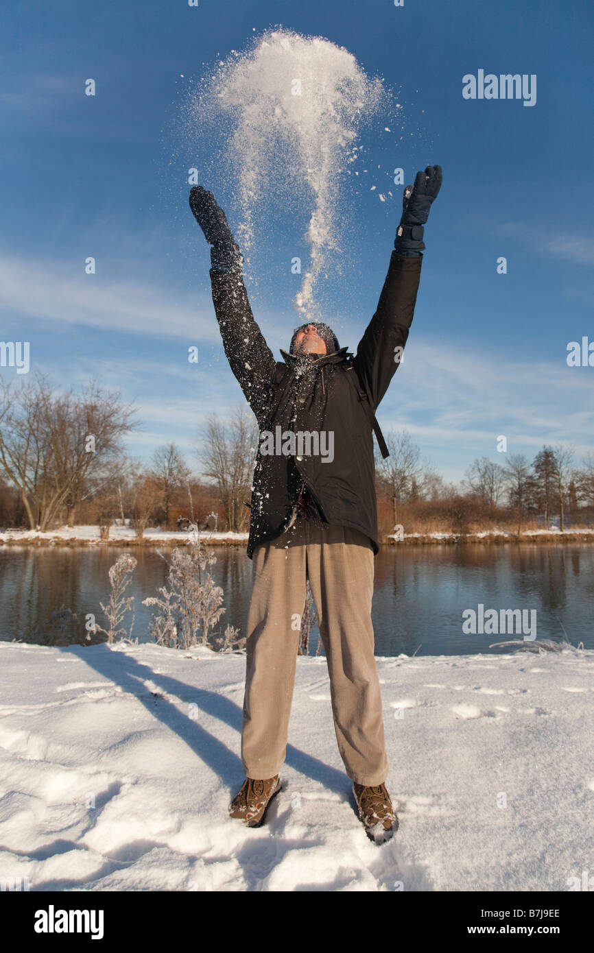 A man having fun and throwing snow in the air during the winter Stock ...