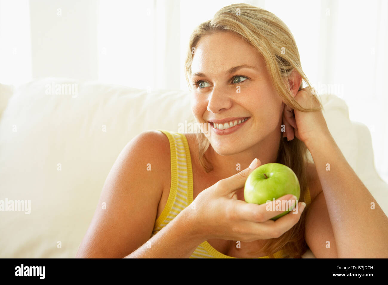 Healthy woman eating a fresh apple, isolated over a white background ...
