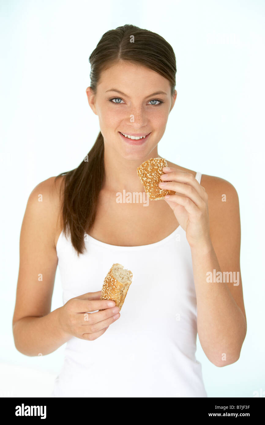 Young Woman Eating A Brown Bread Roll Stock Photo - Alamy