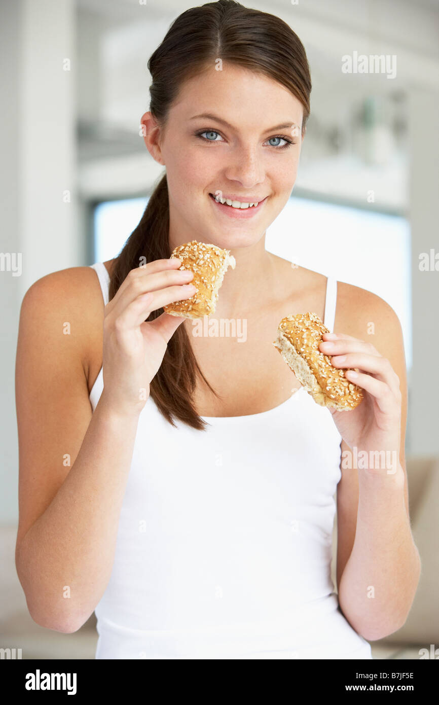 Young Woman Eating Brown Bread Roll Stock Photo - Alamy