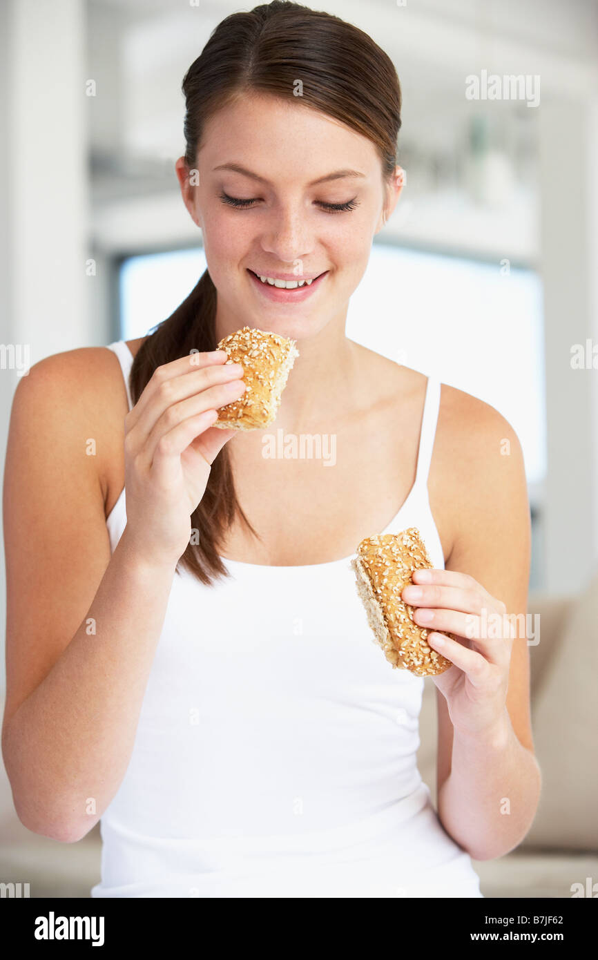 Young Woman Eating Brown Bread Roll Stock Photo - Alamy