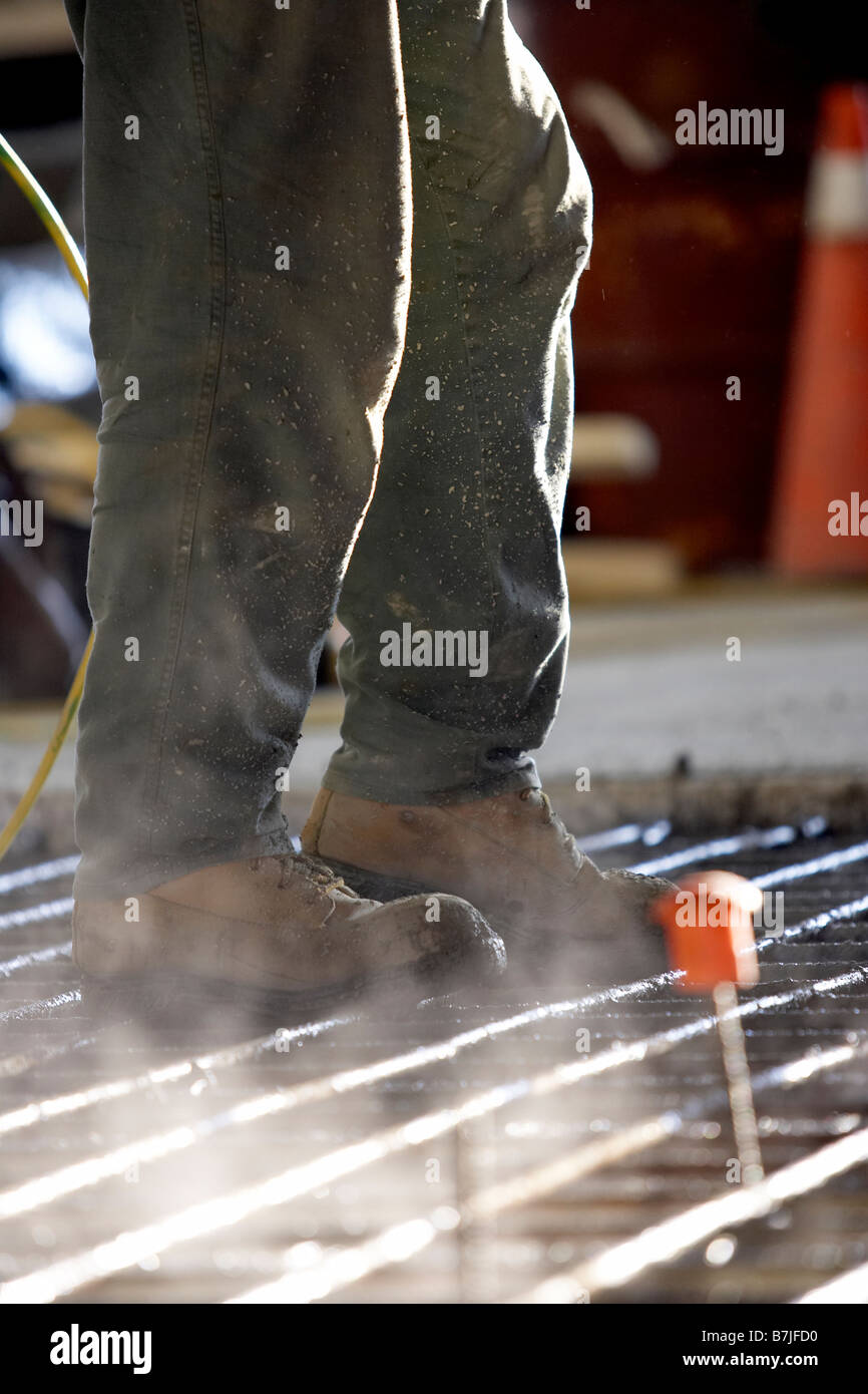 Worker walking on concrete form made of rebar; Canada, Ontario ...