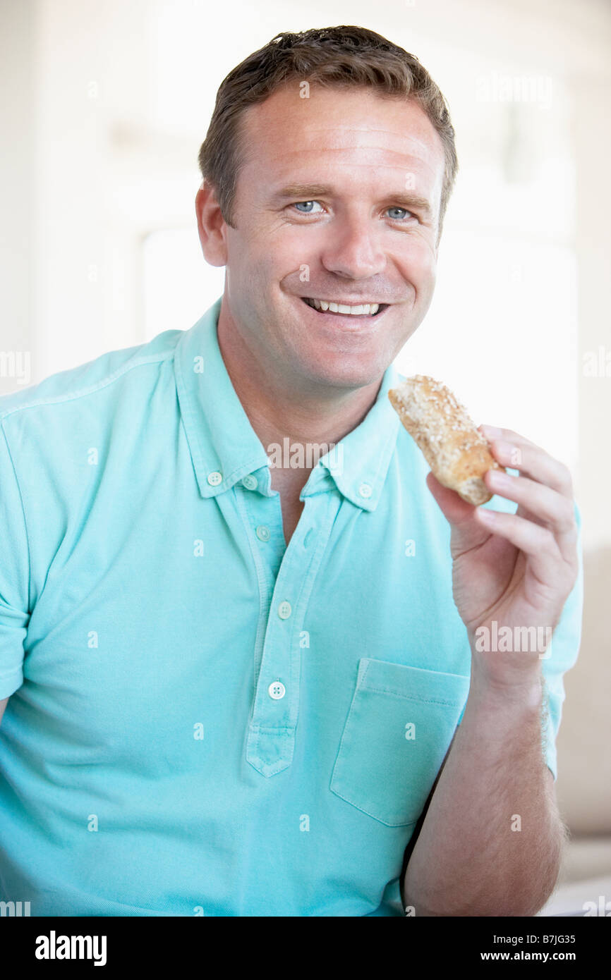 Mid Adult Man Eating Brown Bread Roll Stock Photo - Alamy