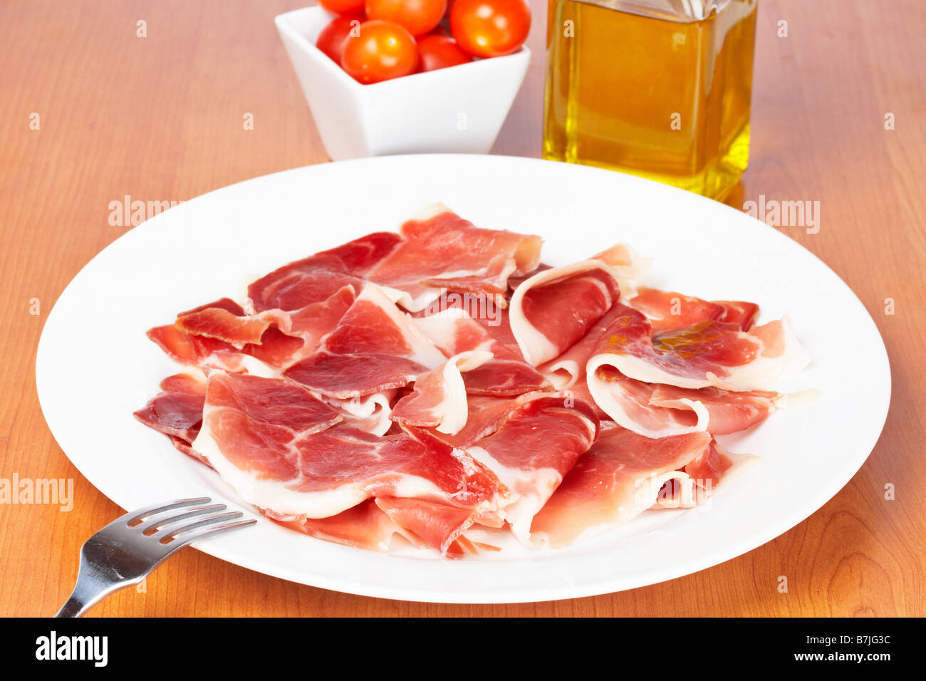 Slices of tasty spanish ham on white dish Shallow depth of field Stock ...