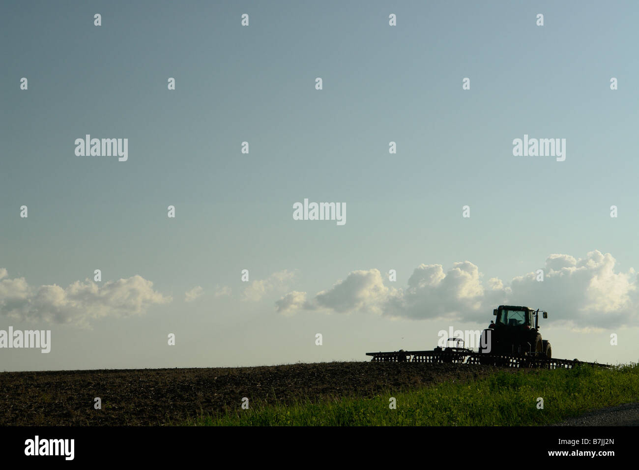Tractor with cultivator at the edge of a field; Canada, Manitoba ...