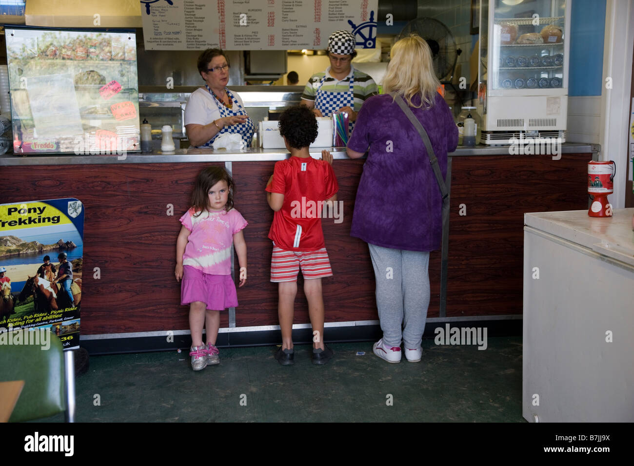 Family buying fish and chips supper in a chip shop Stock Photo - Alamy