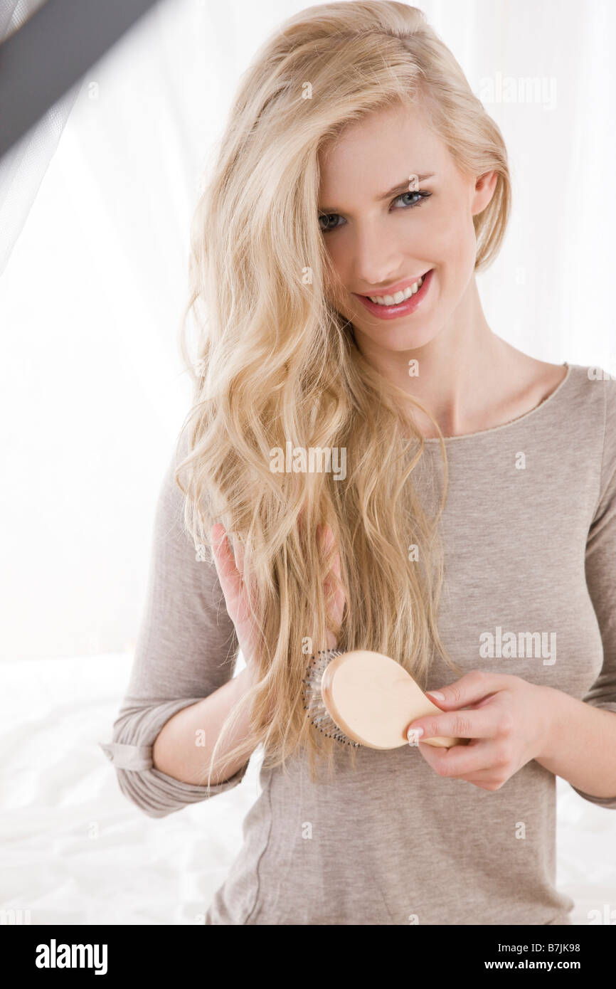 Woman combing hair Stock Photo - Alamy