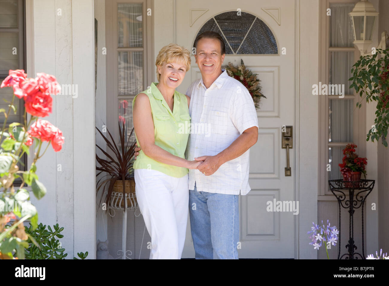 Couple Standing Outside Their House Stock Photo - Alamy