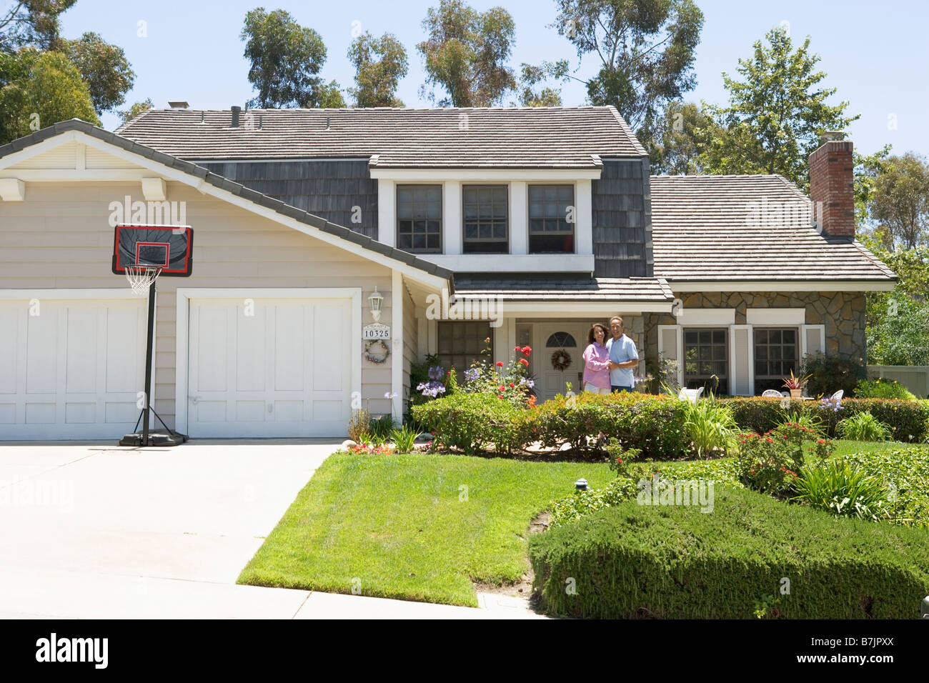 Couple Standing Outside Their House Stock Photo - Alamy