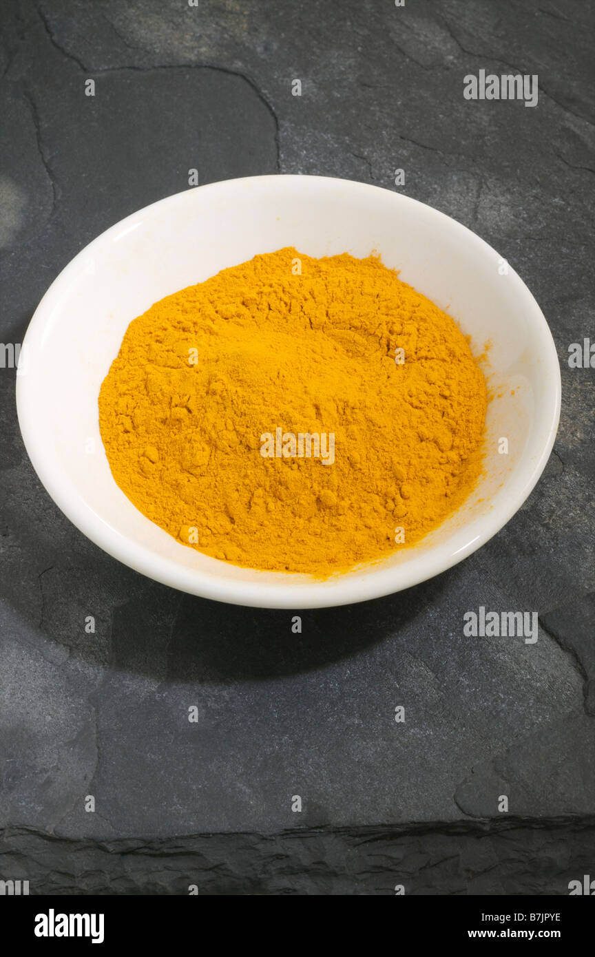Ground Turmeric spice powder ingredient for Indian food in shallow dish ...