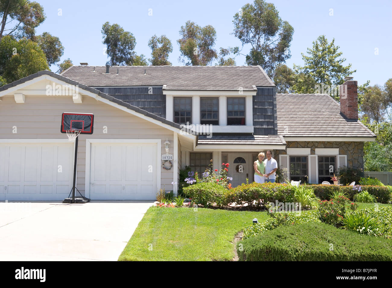 Couple Standing Outside Their House Stock Photo - Alamy