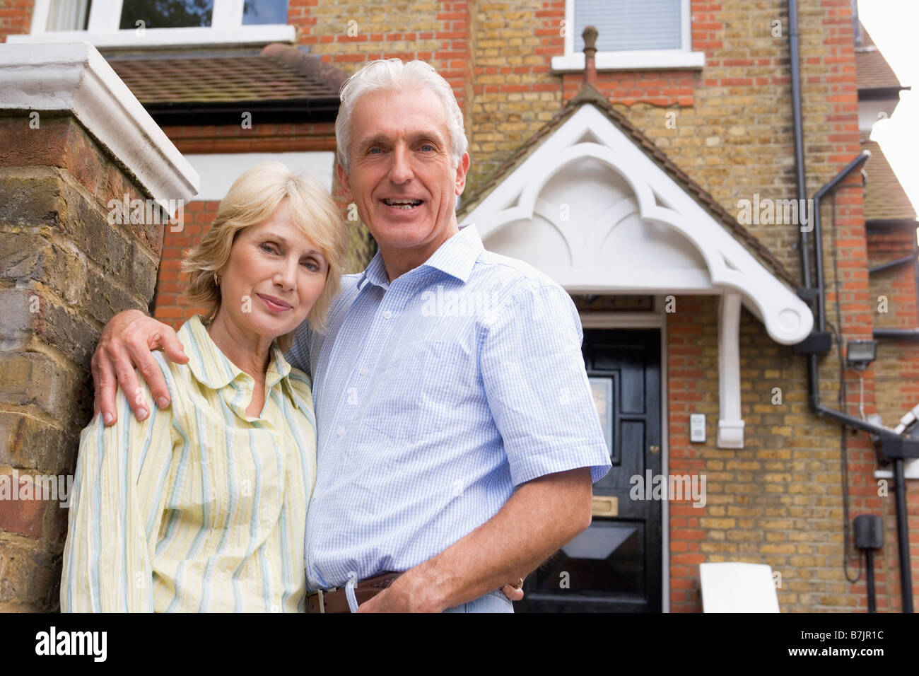 Couple Standing Outside Their House Stock Photo - Alamy