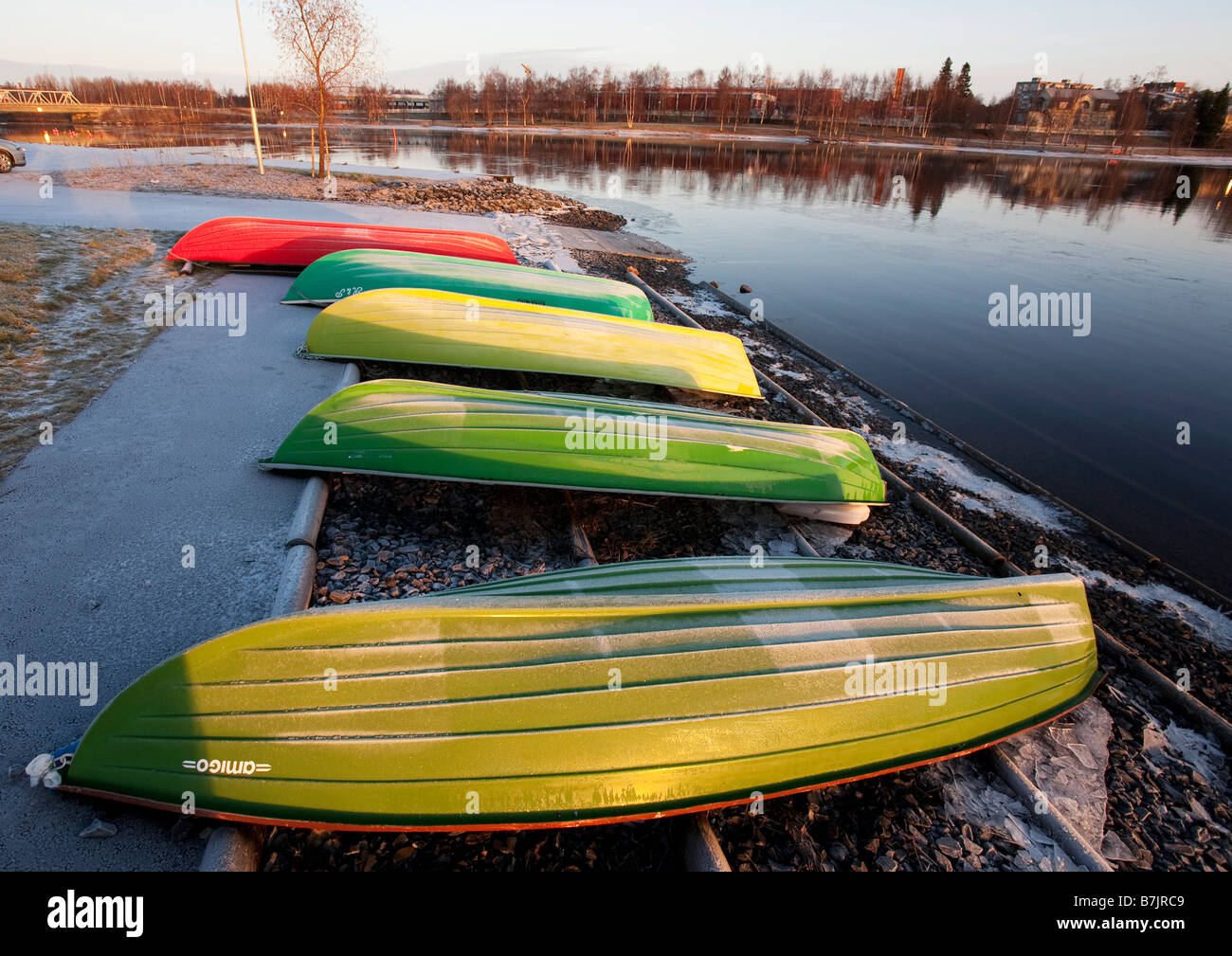 Upturned red and green fiberglass rowboats / skiffs / dinghies beached ...
