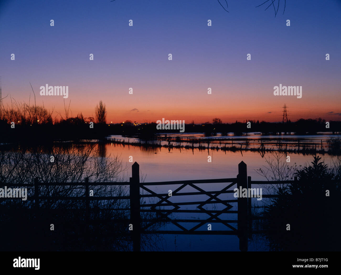 Sunset over flooded fields at Attenborough Pylon in background Gate in ...