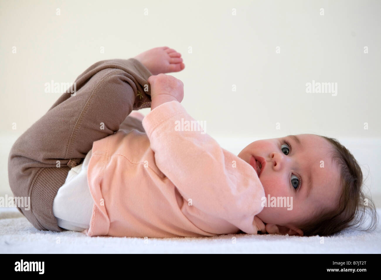 A baby girl rolls around on her back Stock Photo - Alamy