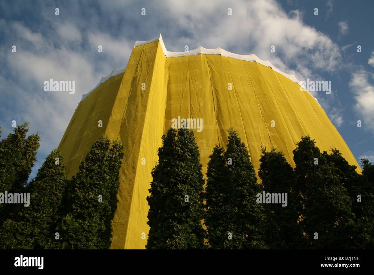 Buidling wrapped in yellow tarp while being painted Stock Photo - Alamy