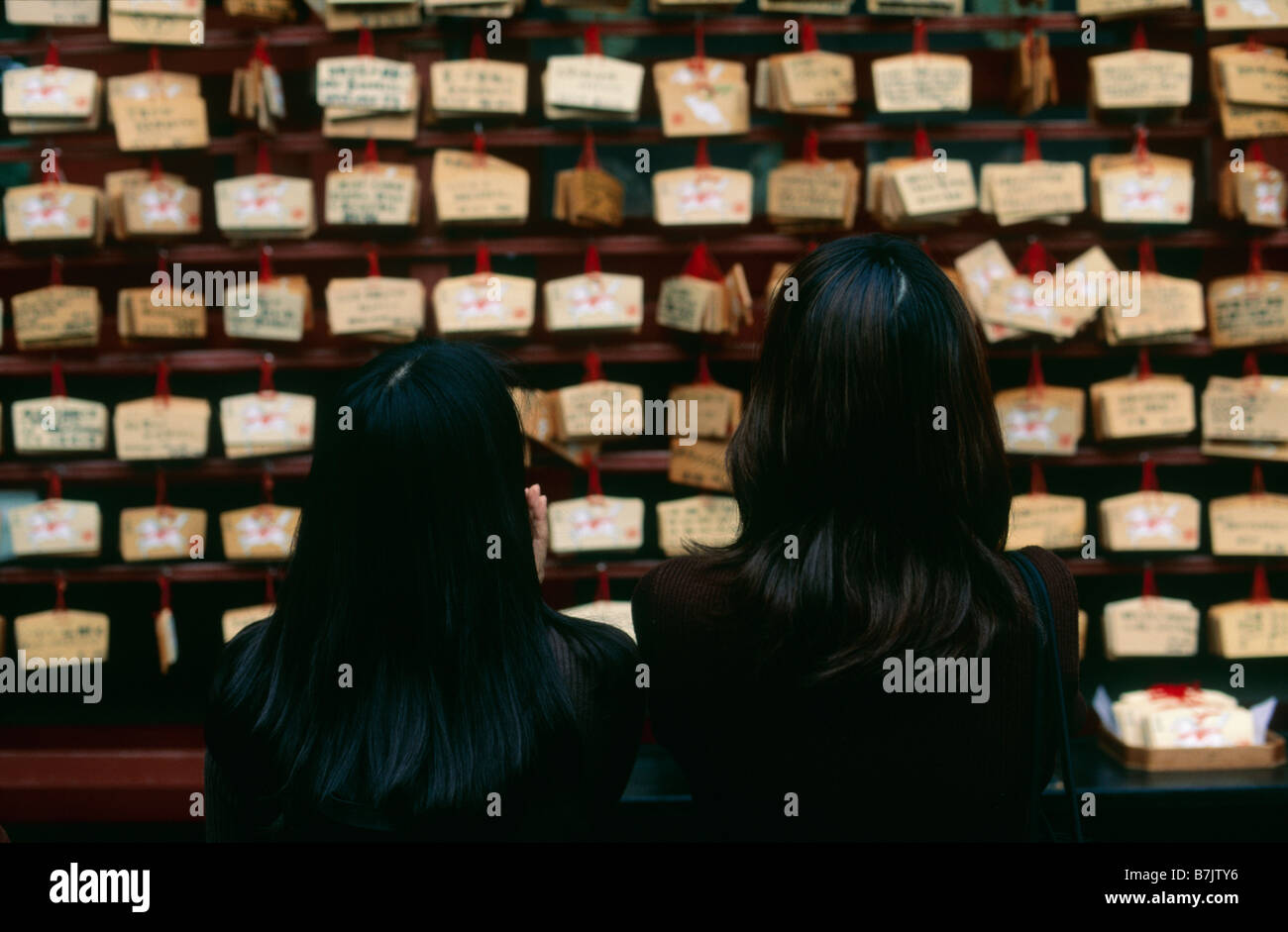 Two girls reading ema, prayers written on wooden blocks, Tsurugaoka ...