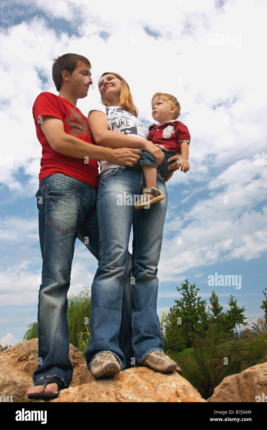 Happy family of three over sky background Stock Photo - Alamy
