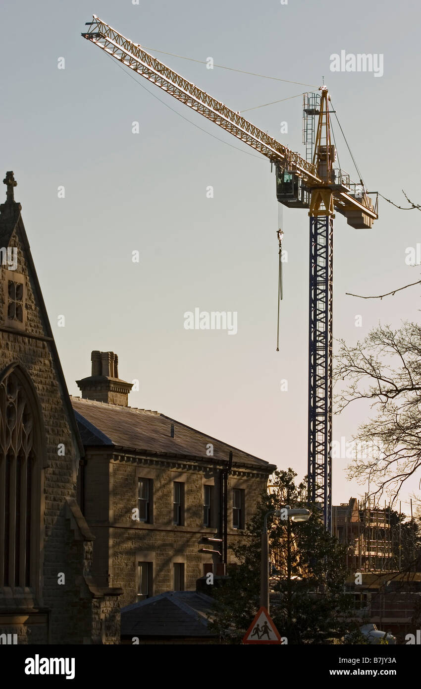 A large construction crane over an old building Stock Photo - Alamy