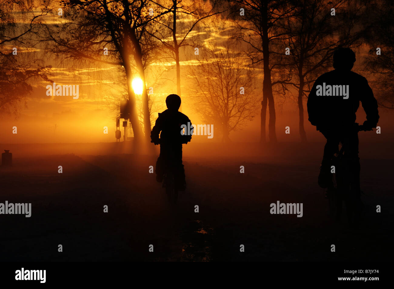Father and son riding through misty sunset Stock Photo - Alamy