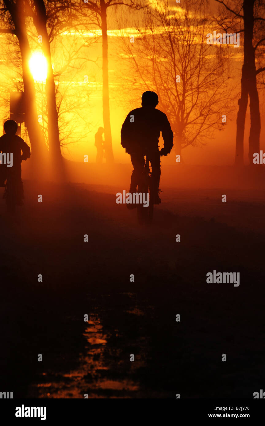 Father and son riding through misty sunset Stock Photo - Alamy