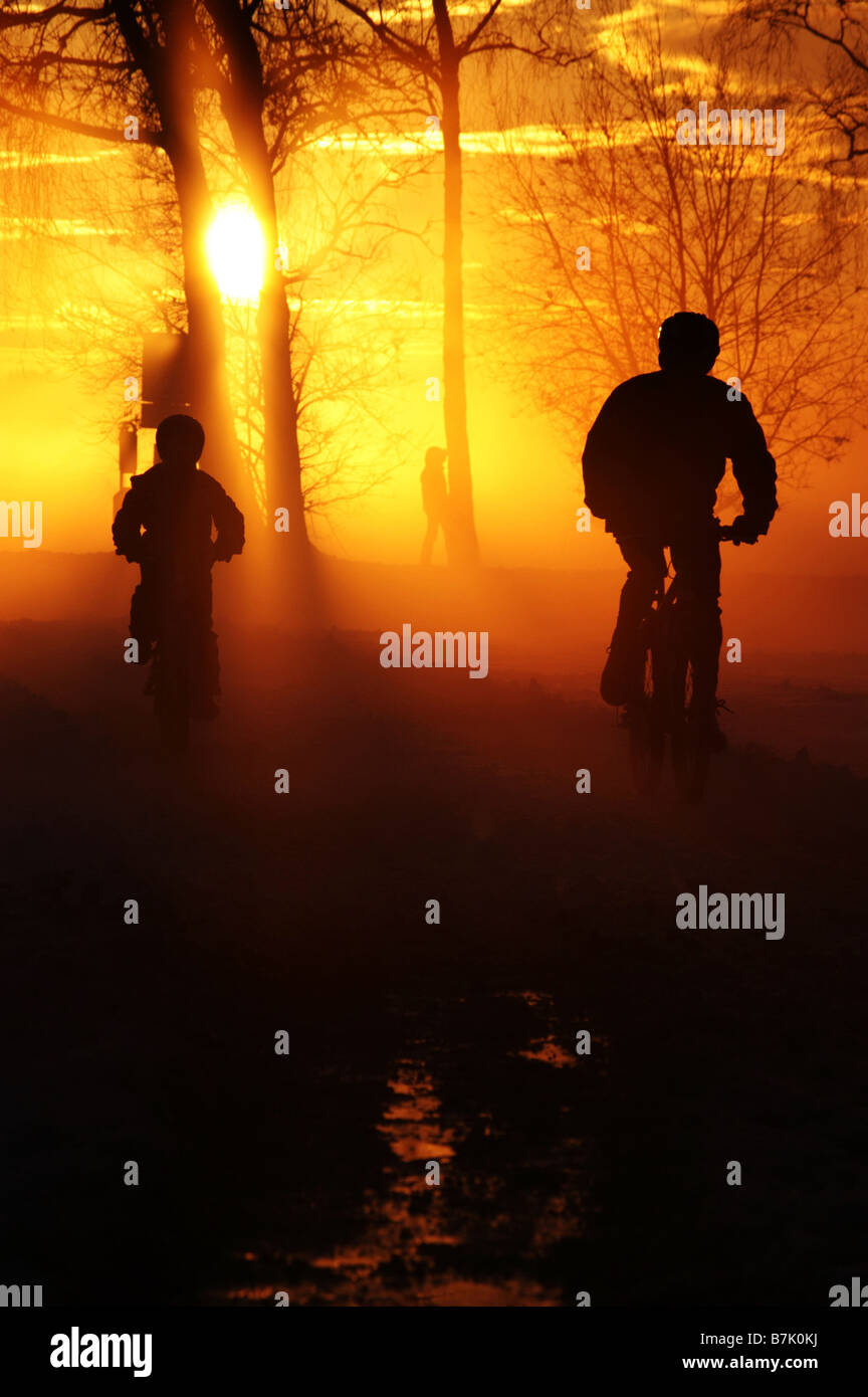 Father and son riding through misty sunset Stock Photo - Alamy