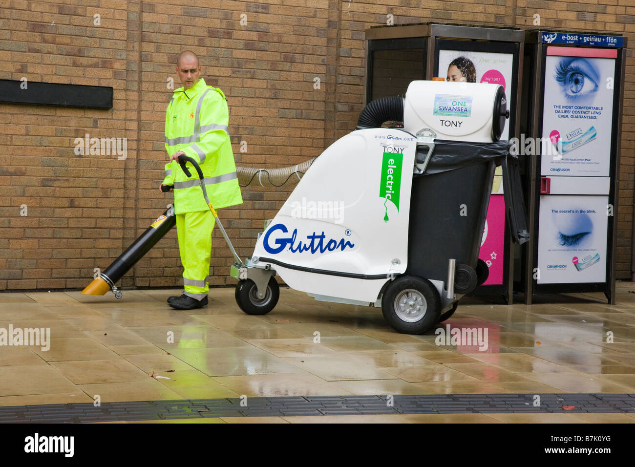 Council workman using The Glutton street vacuum cleaner Stock Photo - Alamy