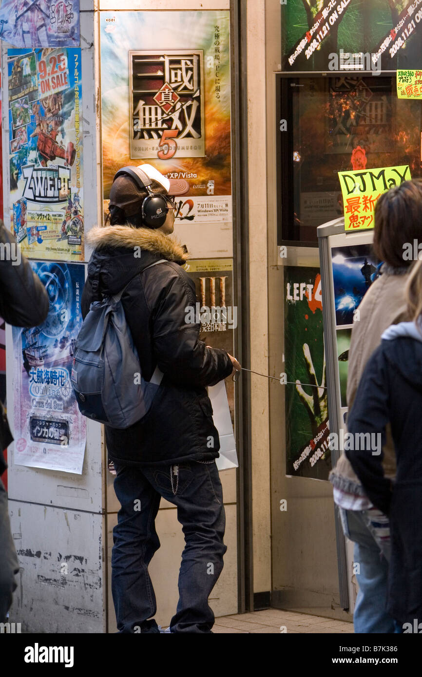Japan boy playing a video game on the street Stock Photo - Alamy