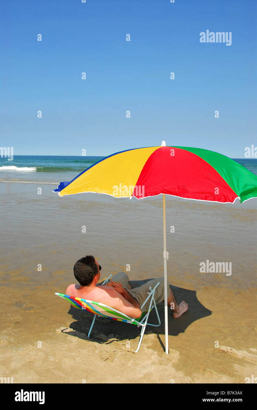 Man relaxing in a beach chair on the ocean shore Stock Photo - Alamy